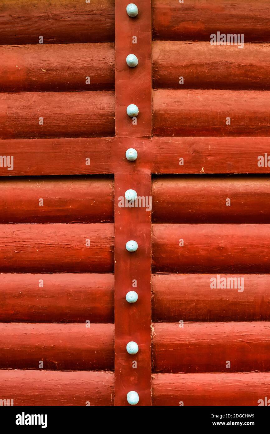 Red logs are folded into a vertical panel with an iron bar bolted Stock ...