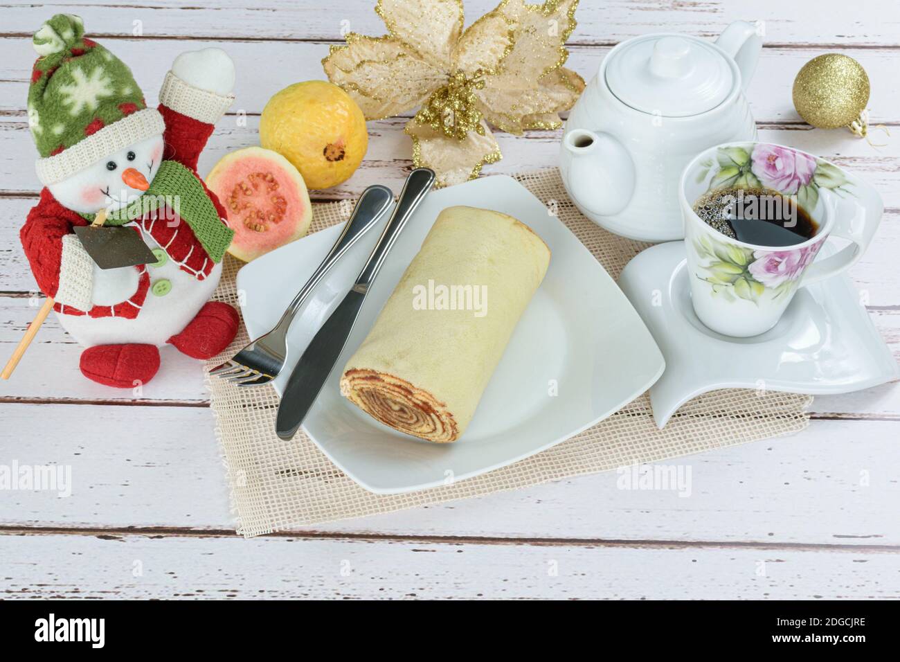 Bolo de rolo (roll cake) next to a Christmas decoration. Traditional ...