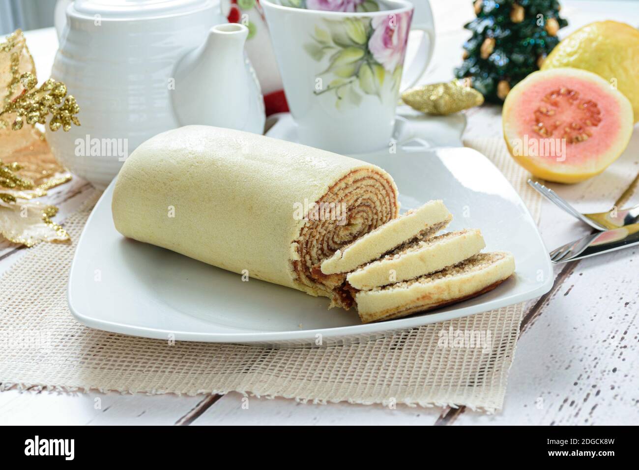 Bolo de rolo (roll cake) sliced next to a Christmas decoration ...