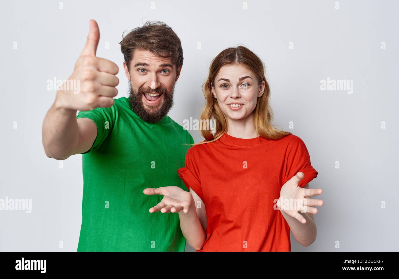 funny man and woman in multicolored t-shirts emotions hand gestures ...