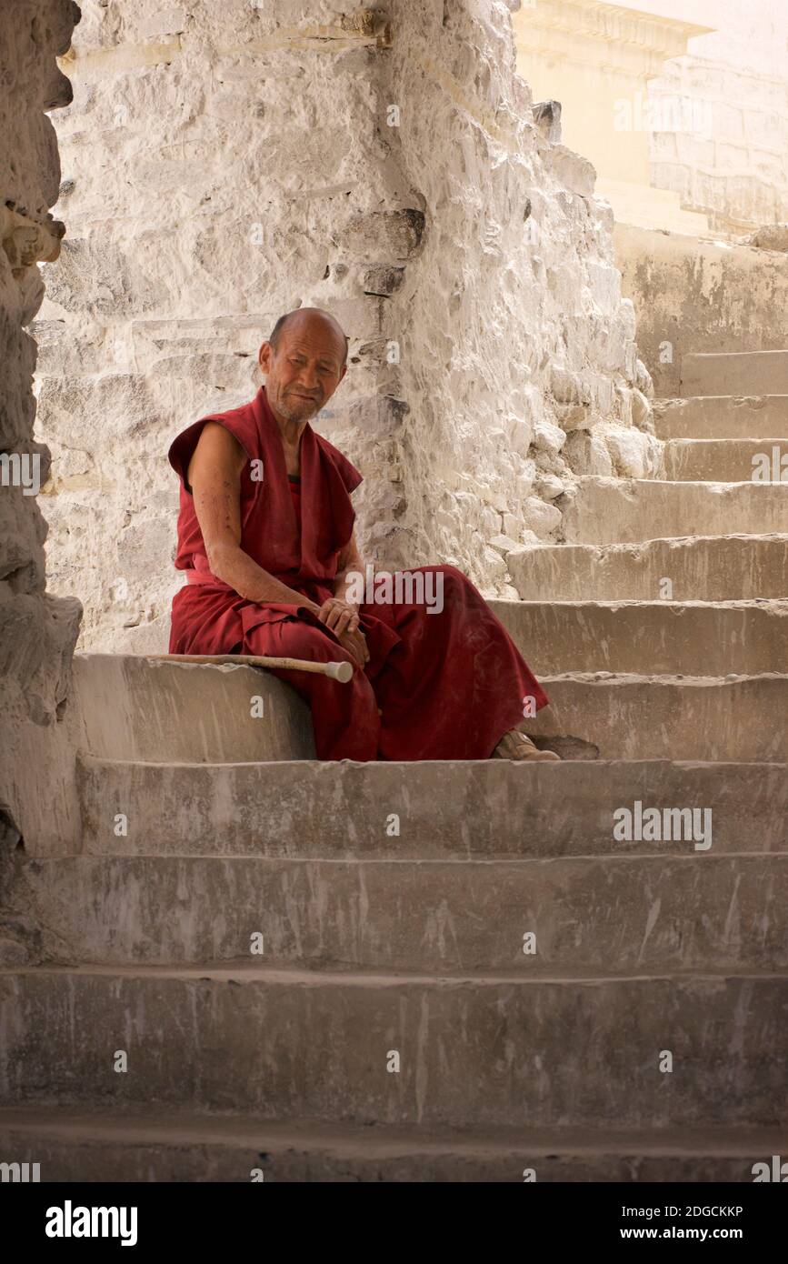 Portrait of a monk sitting on steps at Diskit monastery, also known as ...