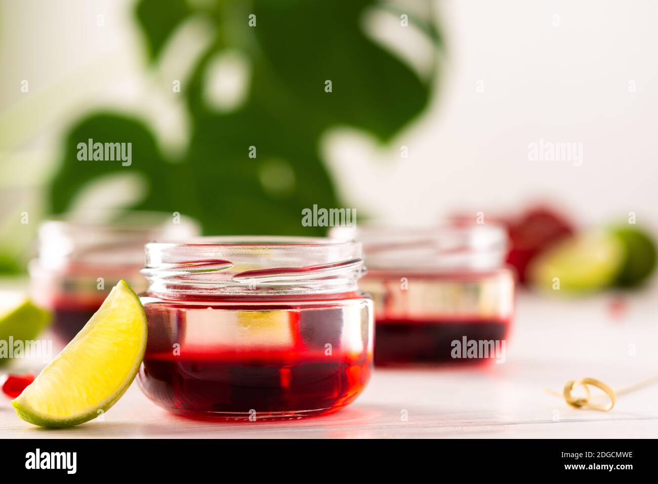 Red alcoholic shots on white background , small jars with liquor and ...
