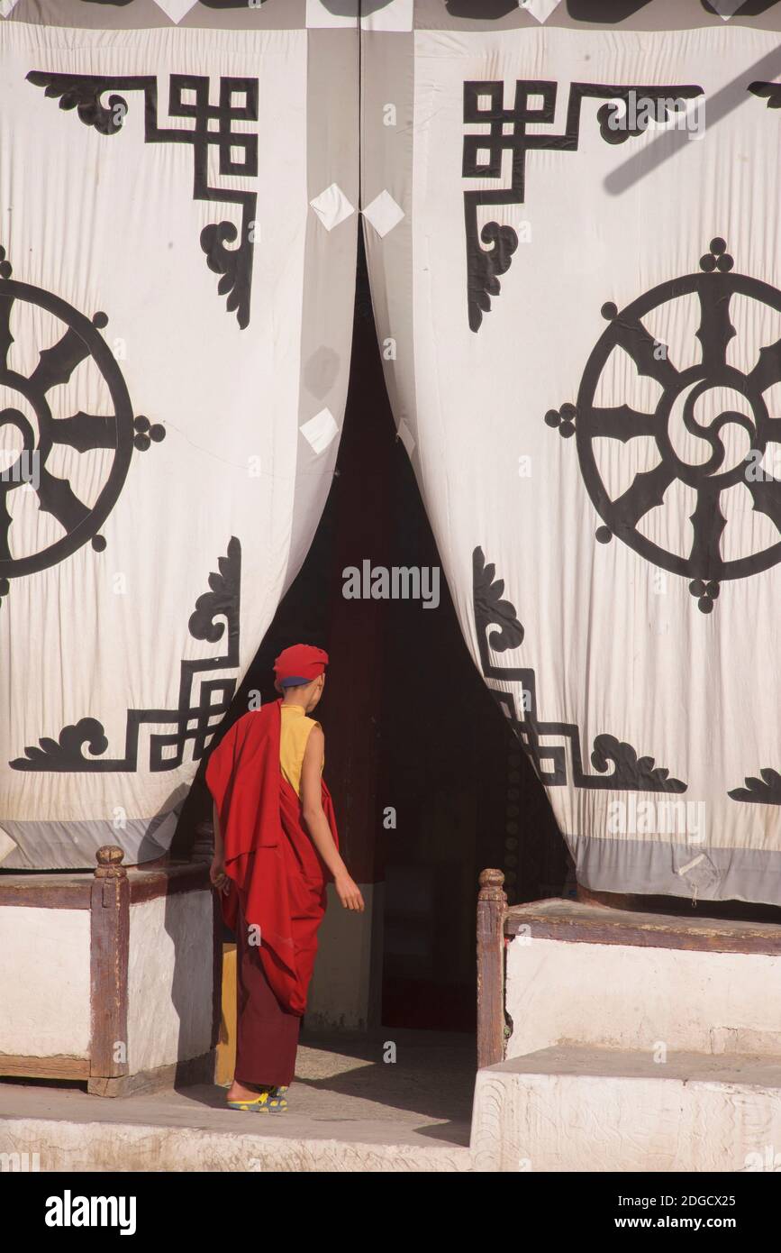 Early morning at Hemis monastery. A young monk entering the prayer hall ...