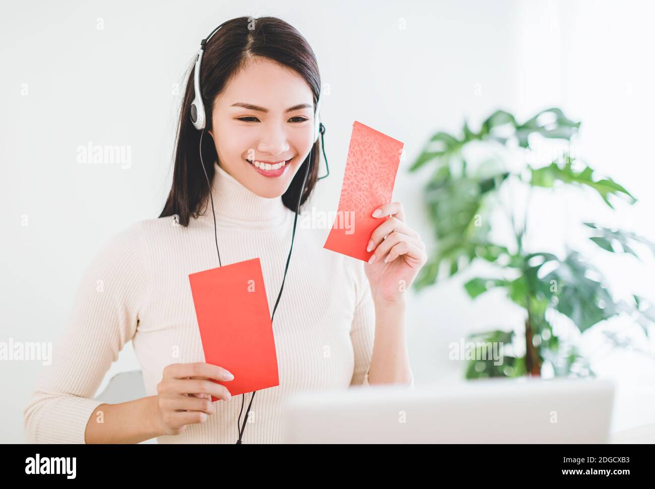 Happy asian young woman making distance video call and showing red ...