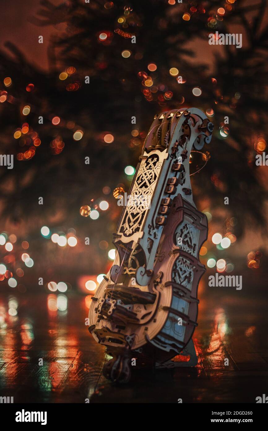 A vertical shot of a handmade string instrument in a Christmas park at ...