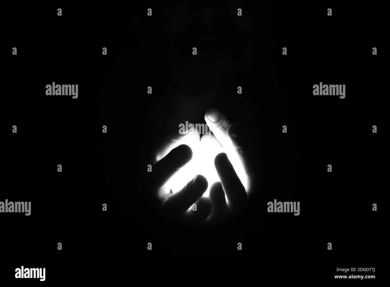 Hands in the dark holding the light between her fingers. Conspiring in ...