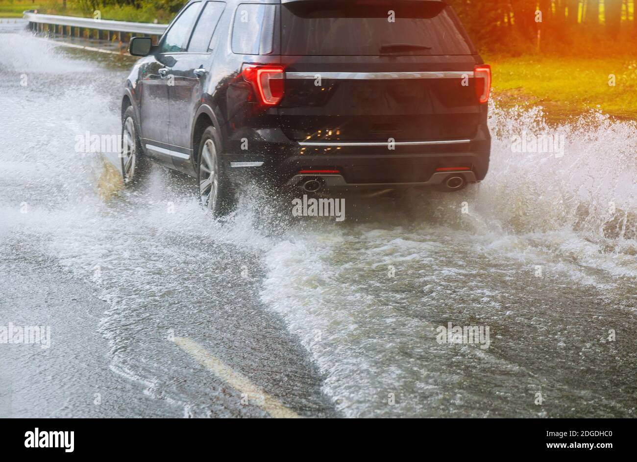 Cars driving on a flooded road during a flood caused by heavy rain ...