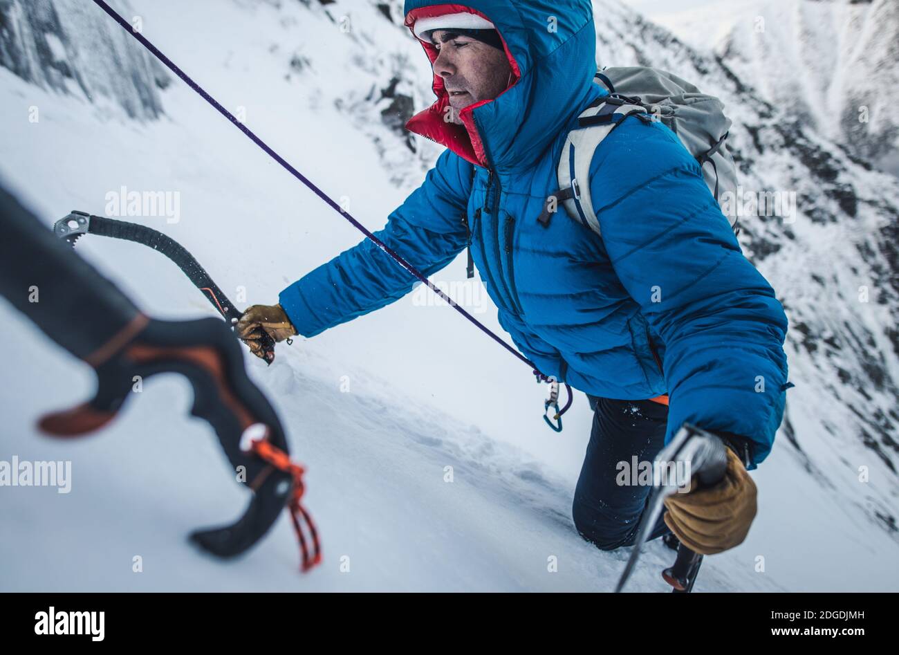 An alpine climber being belayed up a steep section of snow Stock Photo ...