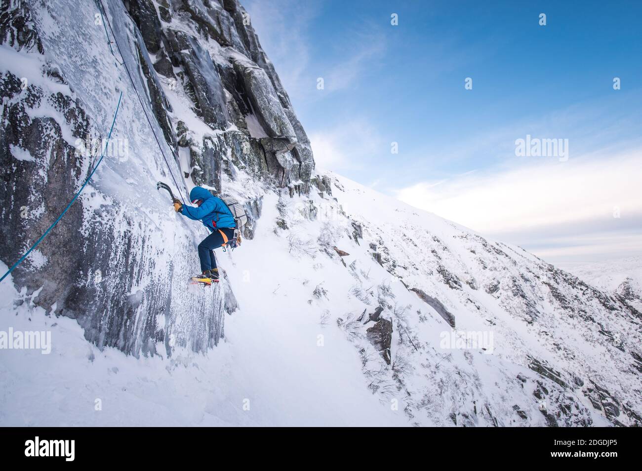 An alpine climber being belayed up a steep section of ice with ...