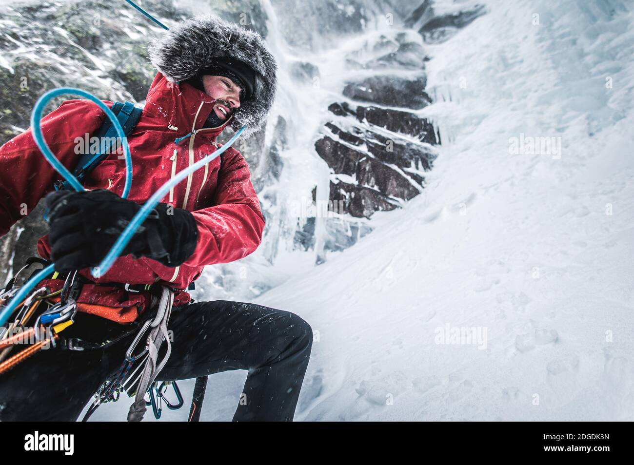 A male ice climber pulls a rope after climbing and rappelling a route ...