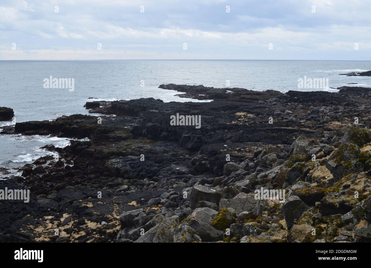 Black lava rocks along the rugged coastline of Iceland Stock Photo - Alamy