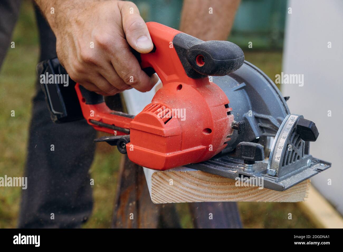 Building contractor worker using hand circular saw to cut boards on a ...