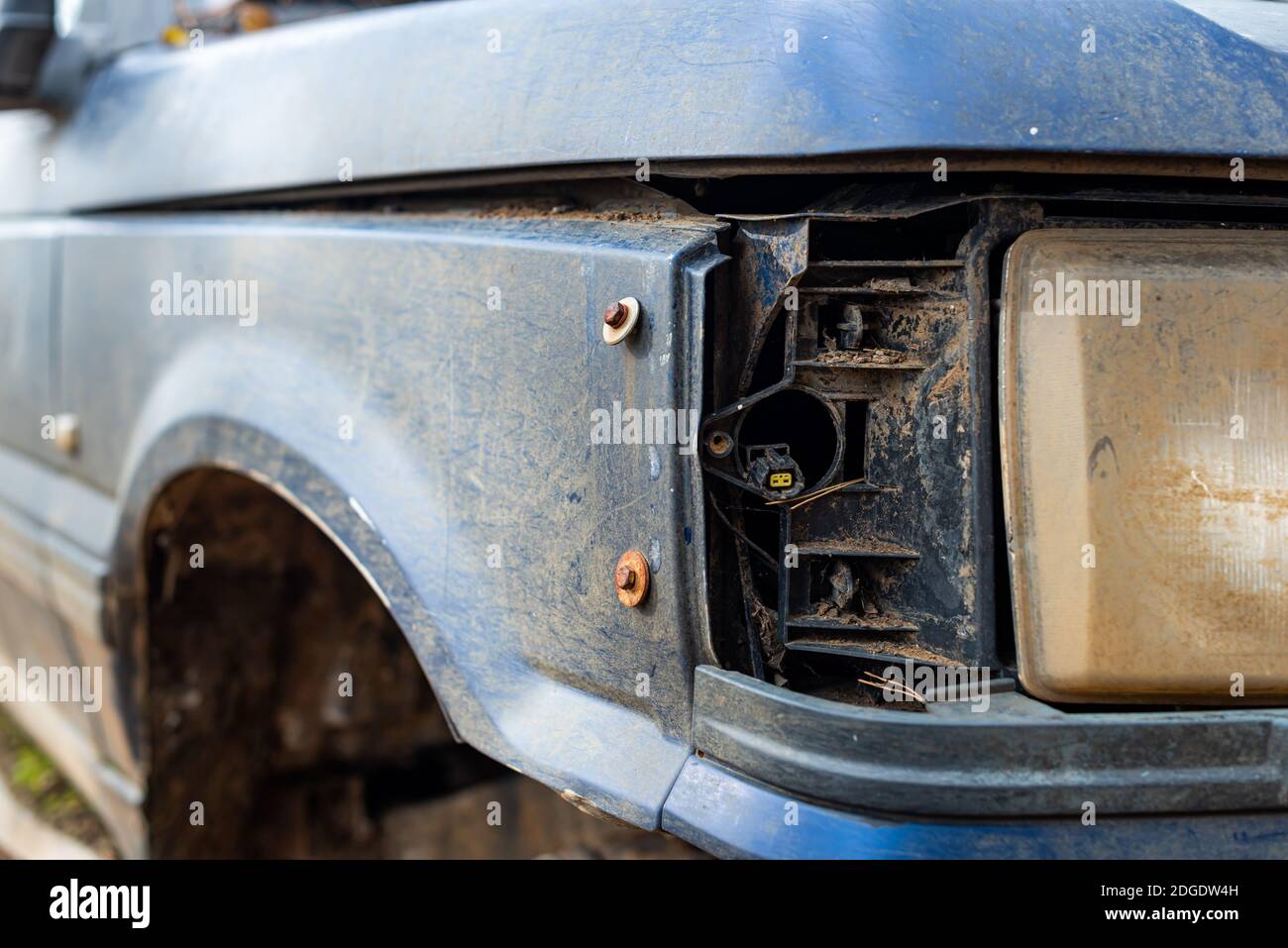 Damaged rusty blue car with repaired headlamp and missing turn light ...
