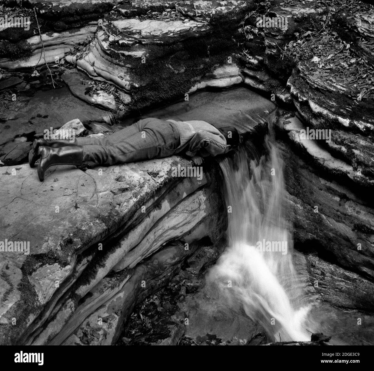 Young female drinking from a small waterfall Stock Photo - Alamy