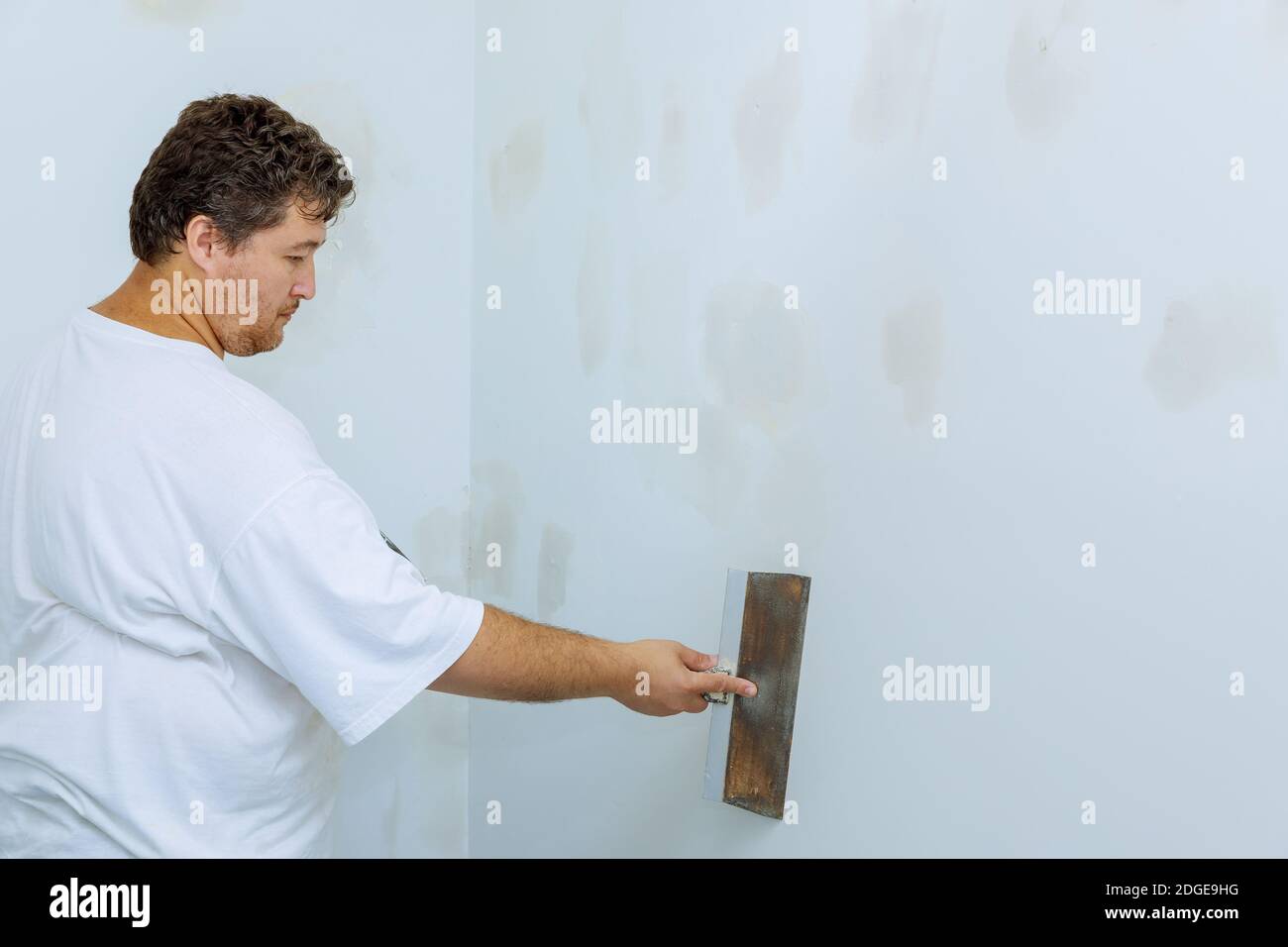 Worker work aligns with a spatula wall Stock Photo - Alamy