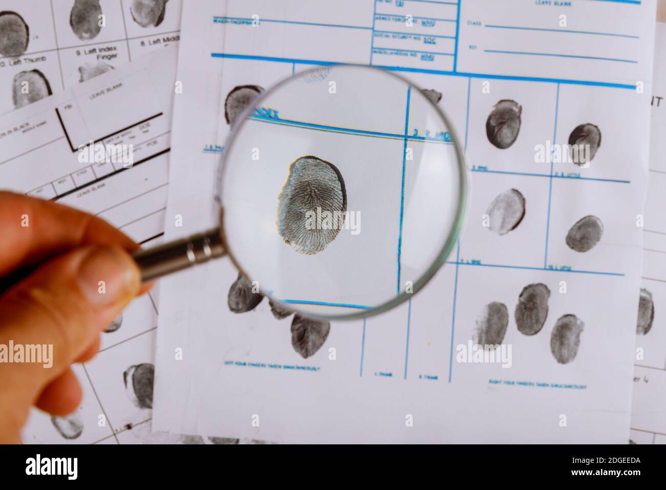 Magnifying glass and criminal fingerprint card, closeup criminalist ...