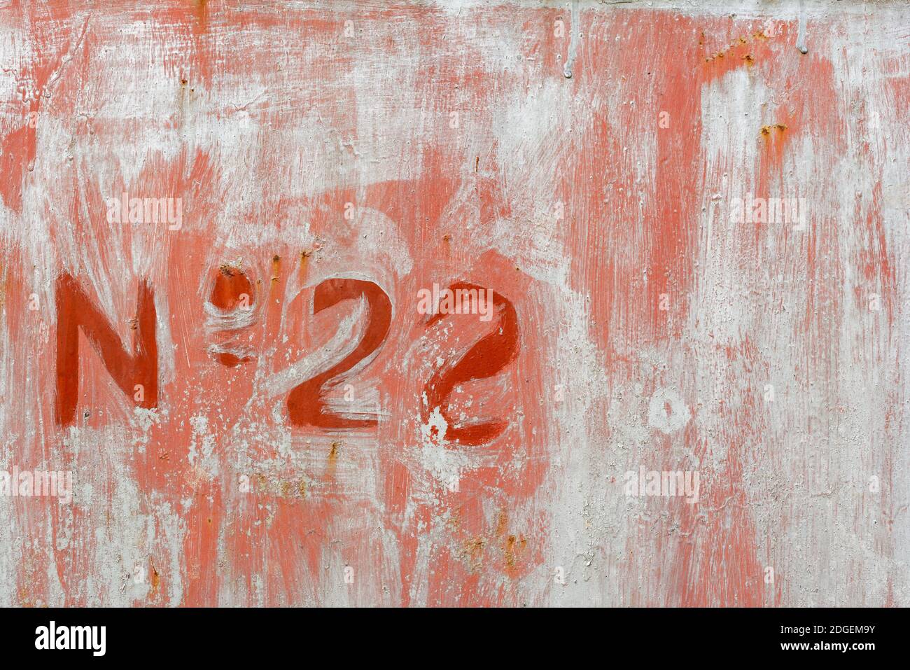 Number 22 sprayed on wall graffiti red on red and grey rust texture ...