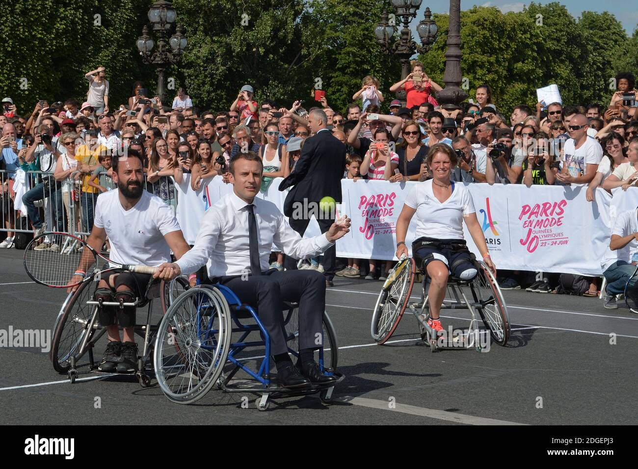 French President Emmanuel Macron plays tennis during a visit to a site ...