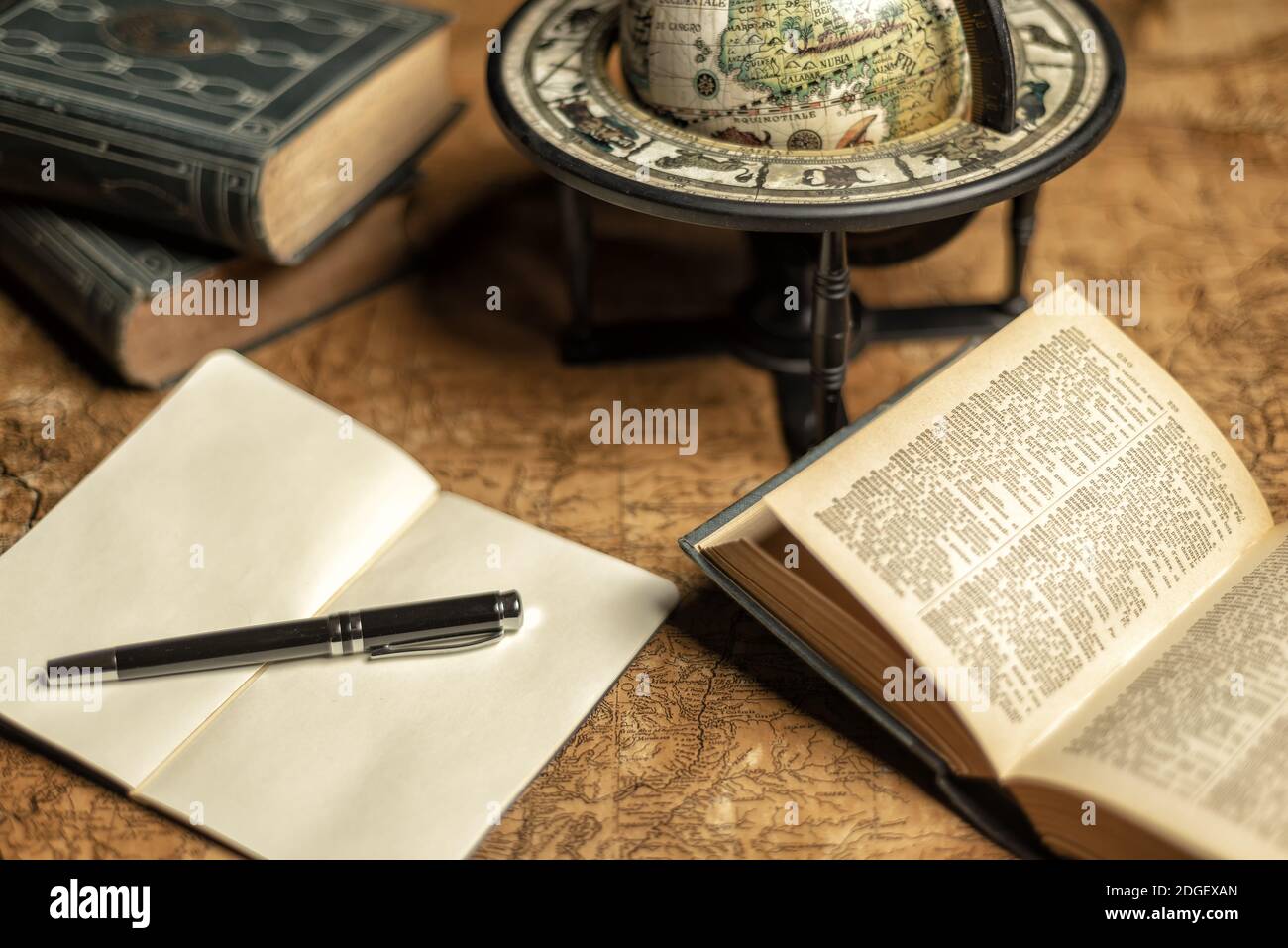 Old expedition map with notebook. books and globe Stock Photo - Alamy
