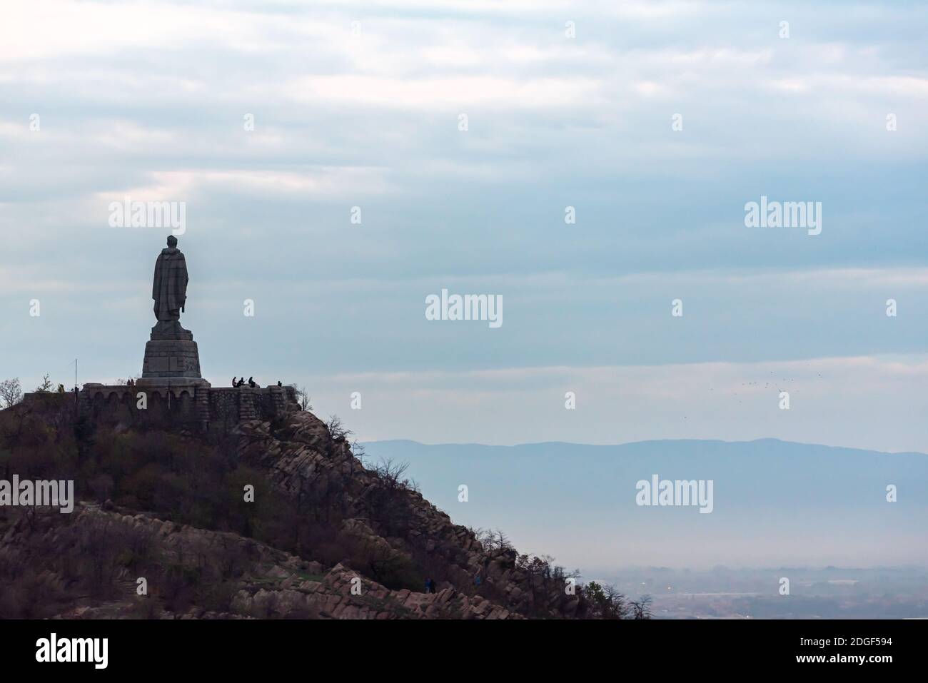 High statue on a hill looking over a massive Eastern European city of ...