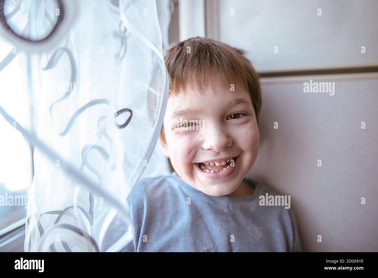 Portrait of playful laughting little boy at the window Stock Photo - Alamy