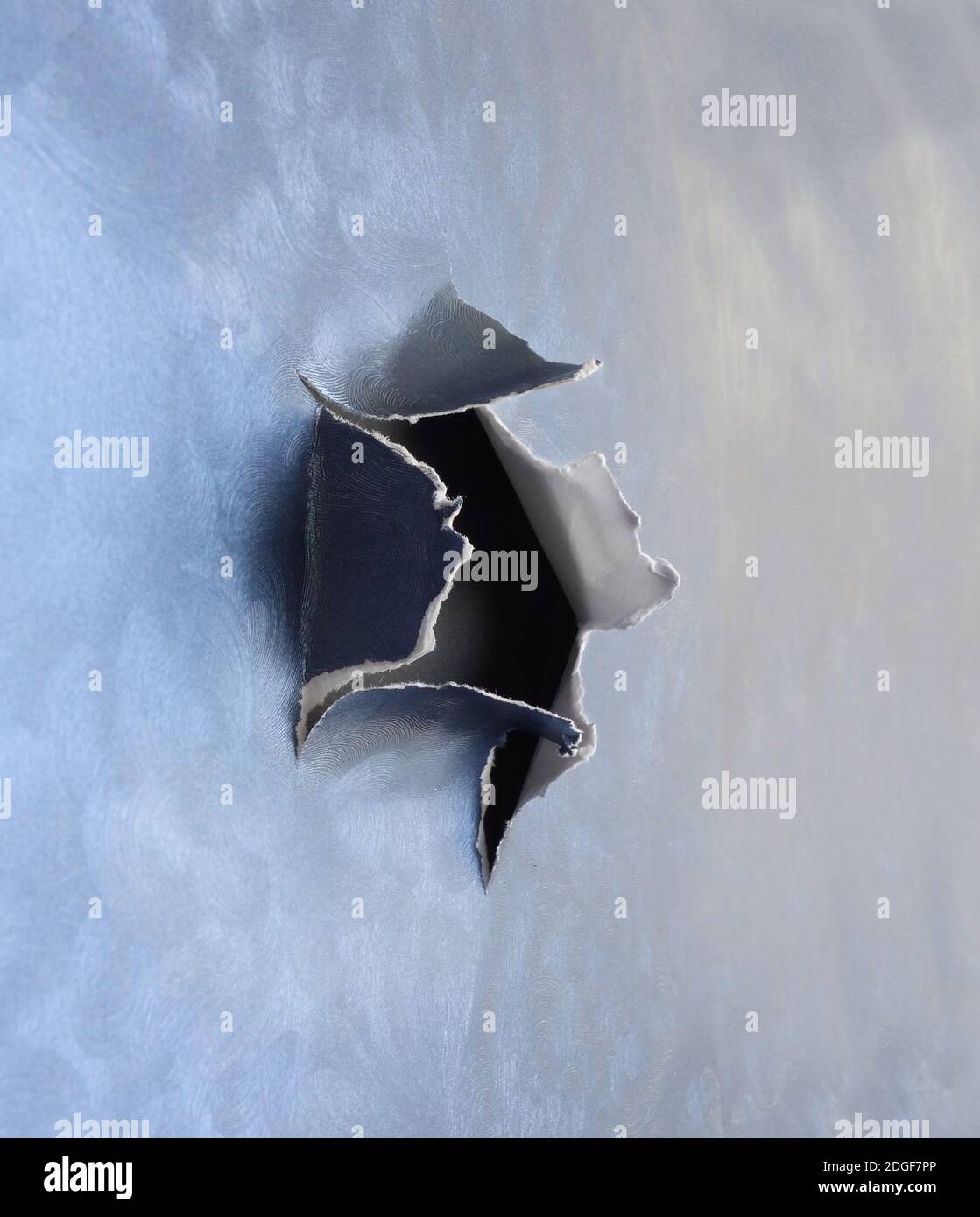 Side view of blue paper hole tear Stock Photo - Alamy