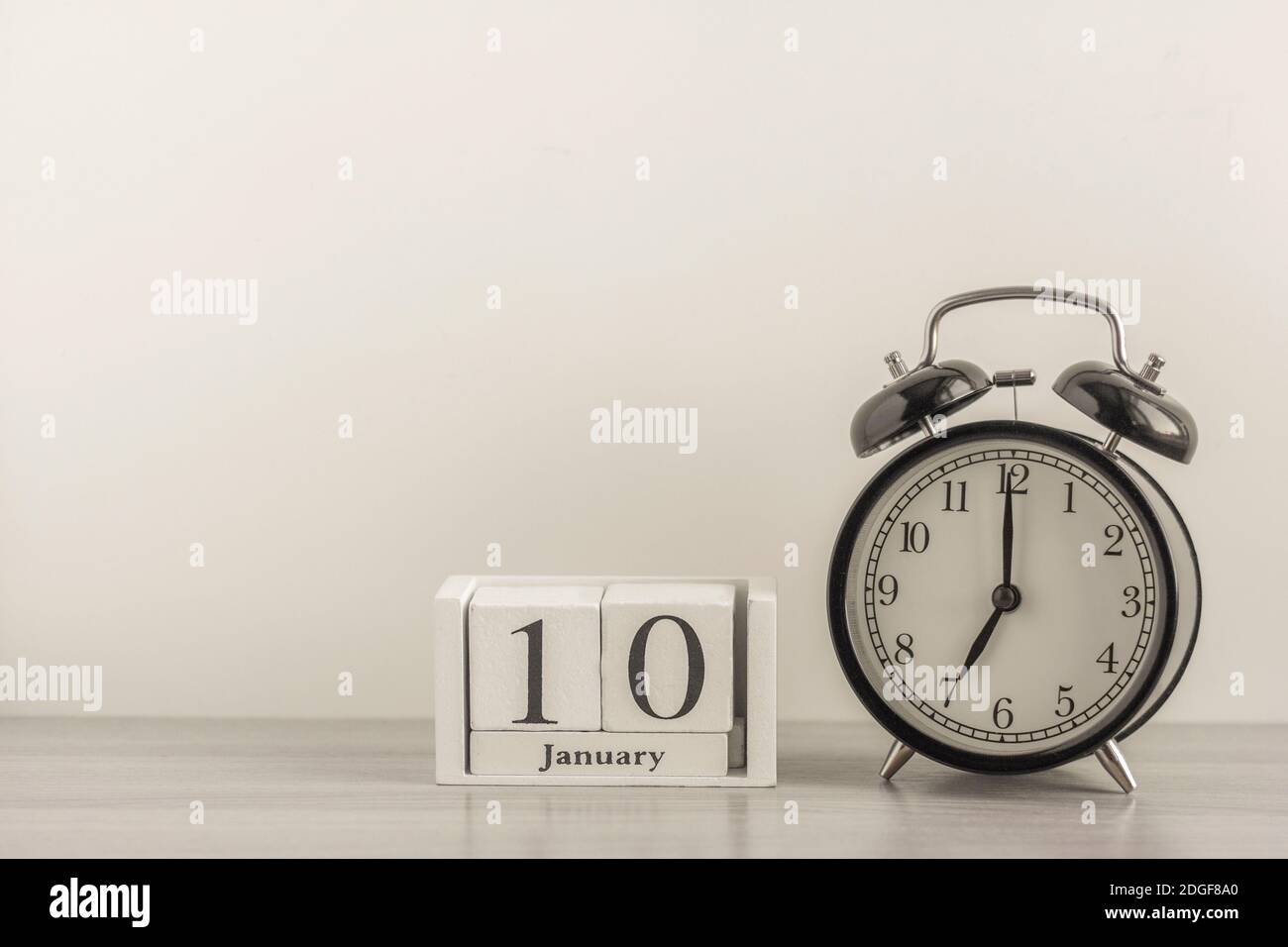 January 5 on a white calendar, next to a retro alarm clock on a light ...