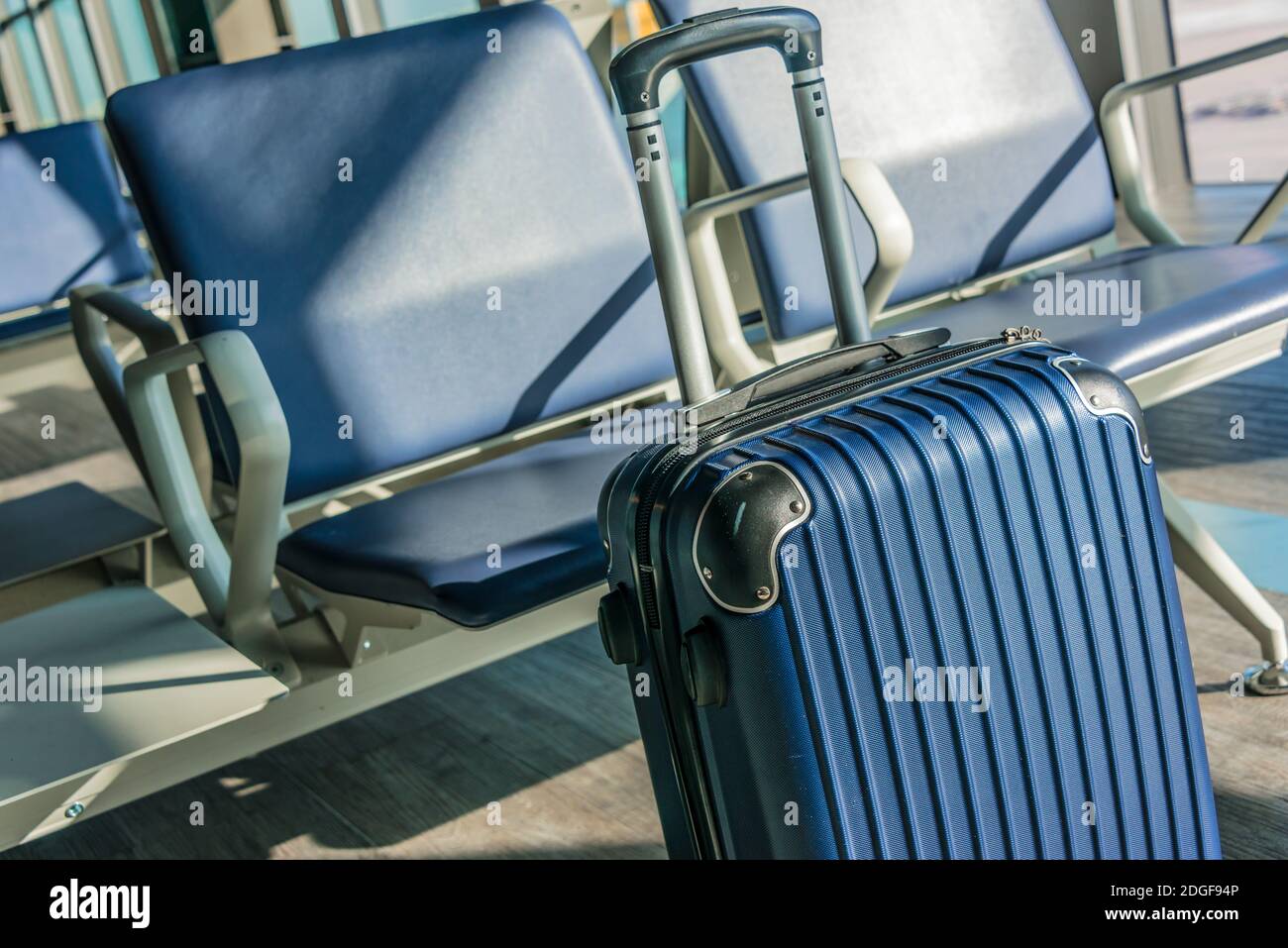 Small plastic travel suitcase in the airport hall Stock Photo - Alamy