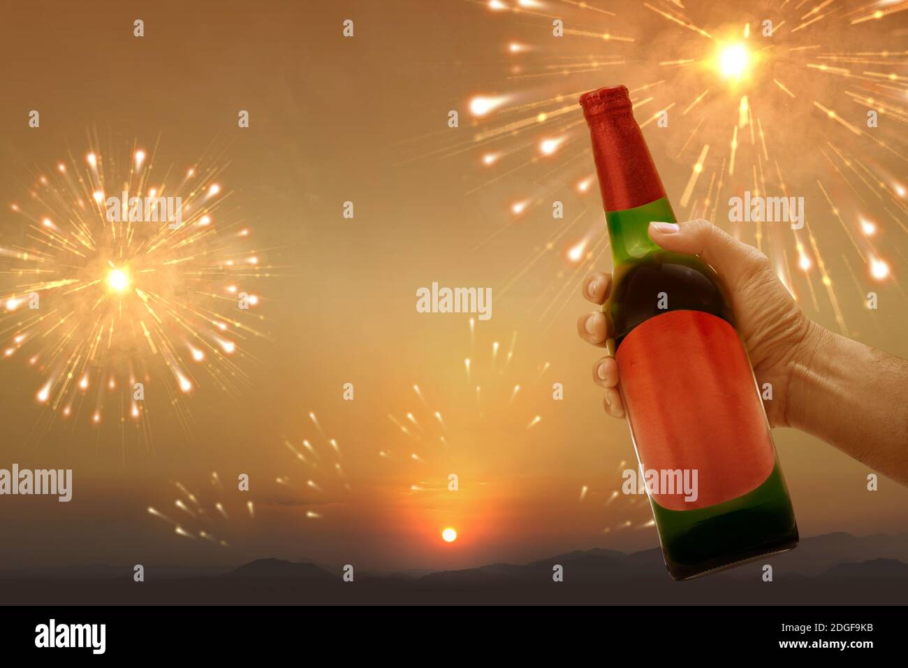 Hand holding beer bottle with fireworks background Stock Photo - Alamy