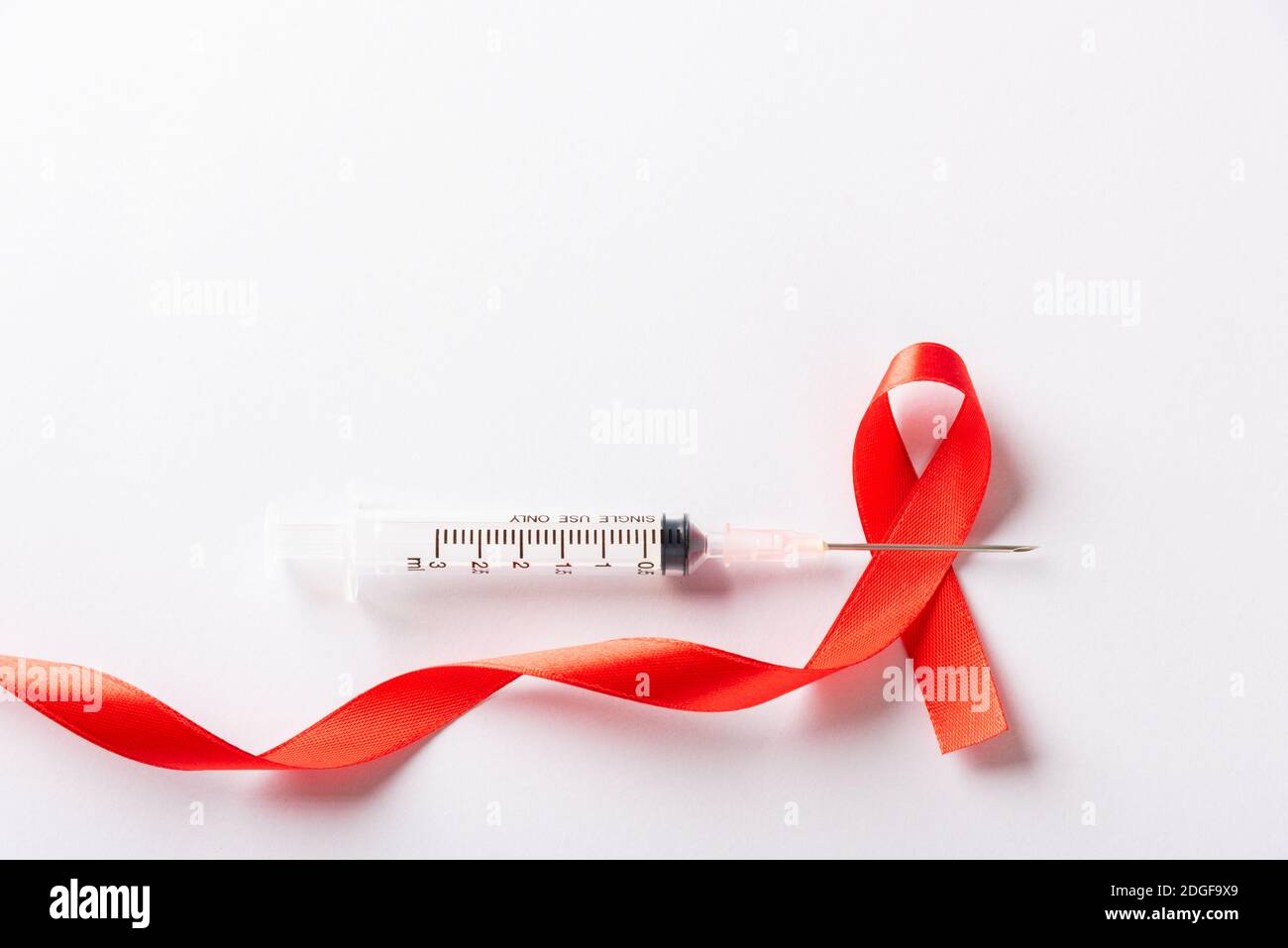 Red bow ribbon symbol HIV, AIDS cancer awareness and syringe with ...