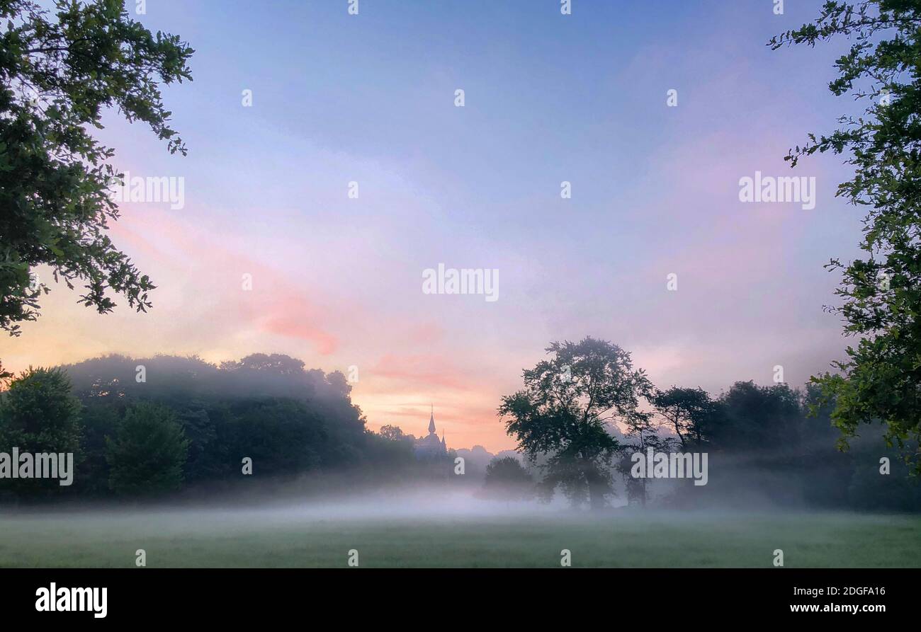 Colorful glowing sunrise over a distant castle Stock Photo - Alamy