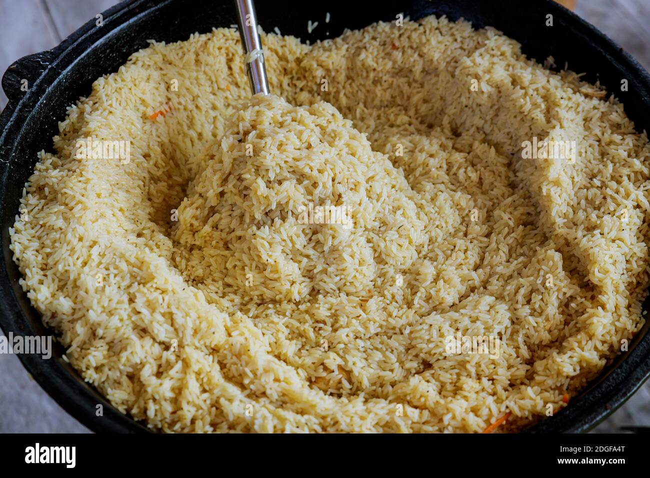 Cooking rice with carrots in iron cauldron. Arabic cuisine Stock Photo ...