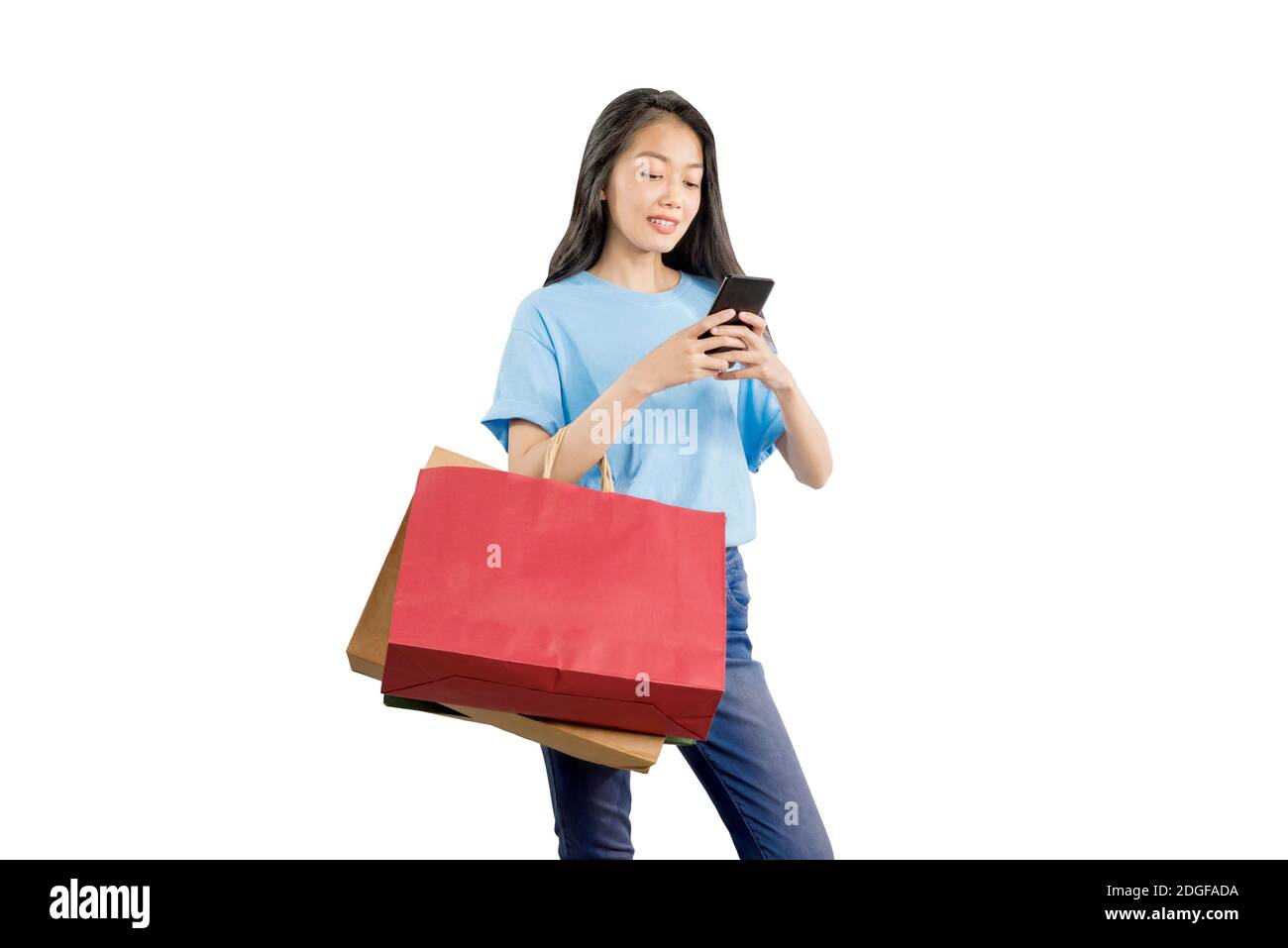 Asian woman carrying shopping bags holding mobile phone isolated over ...
