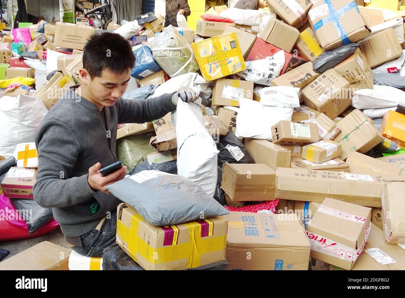 People look for delivers in a pile of parcels stockpiled in front of a ...