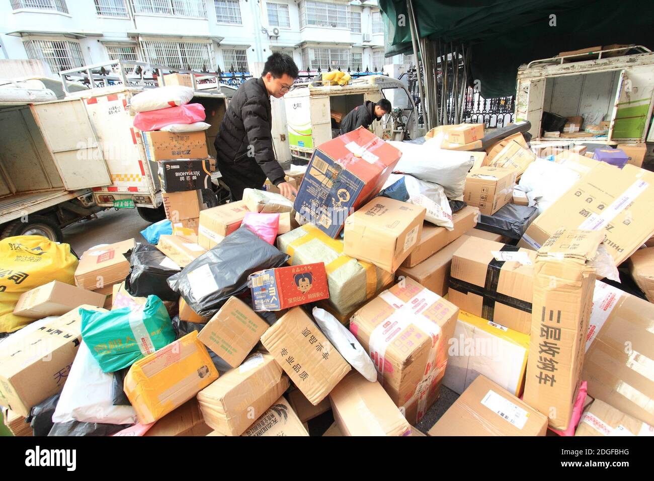 People look for delivers in a pile of parcels stockpiled in front of a ...