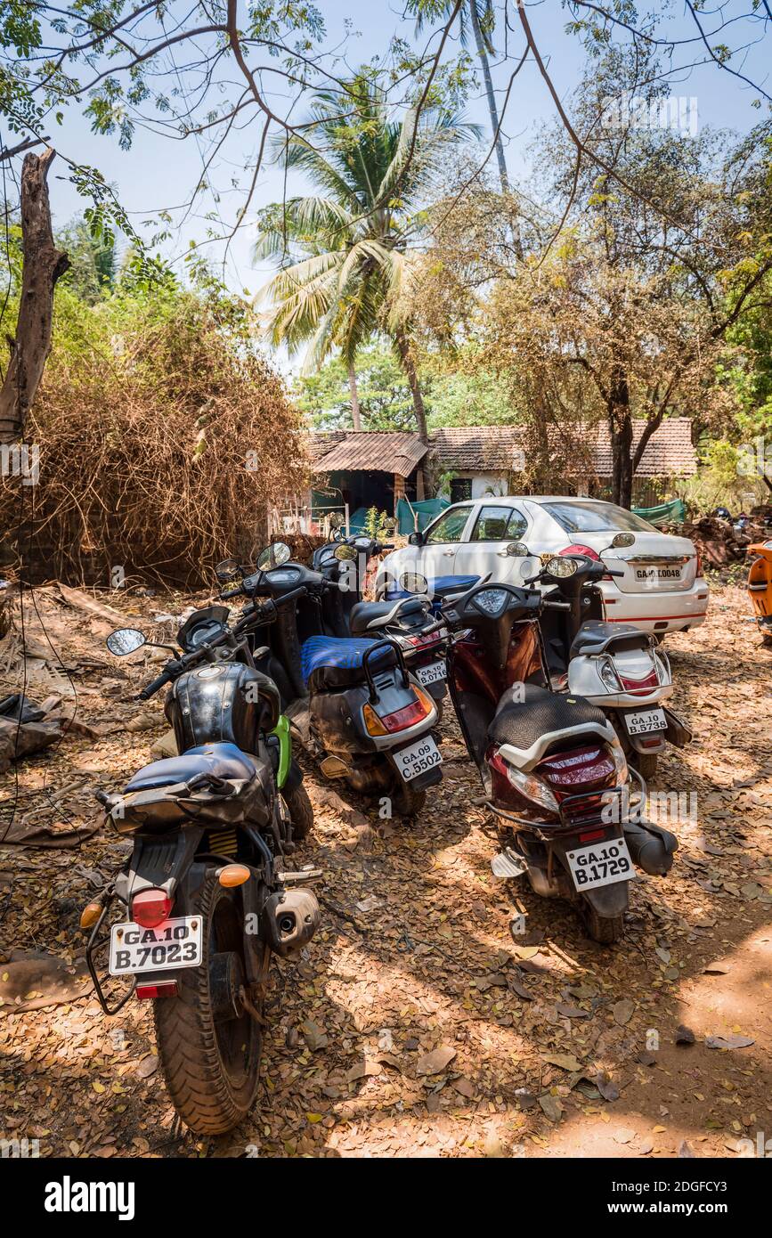 Car and motorcycles near houses in a village in Goa, India Stock Photo ...