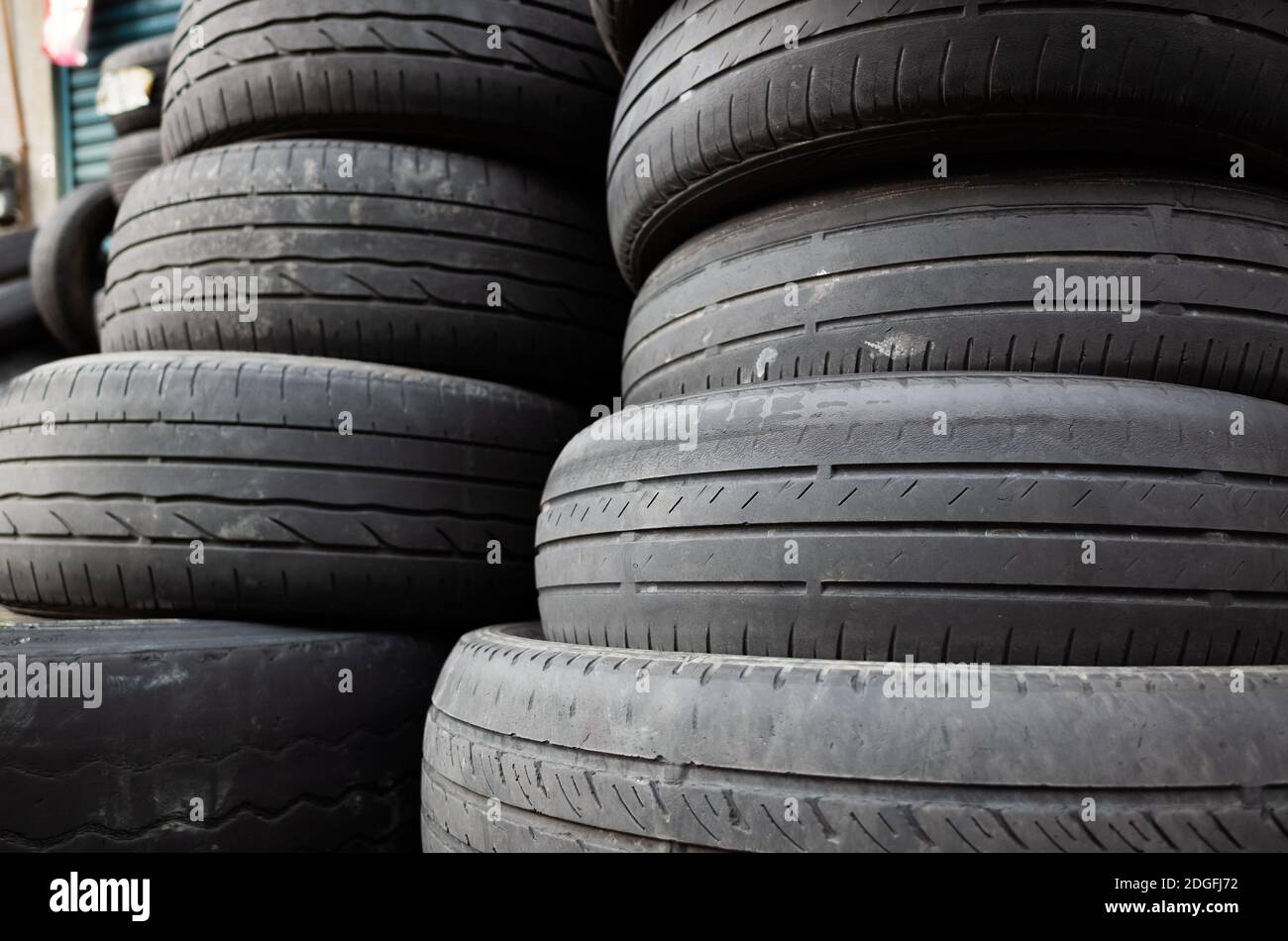 Old used car tires stacked in piles Stock Photo - Alamy