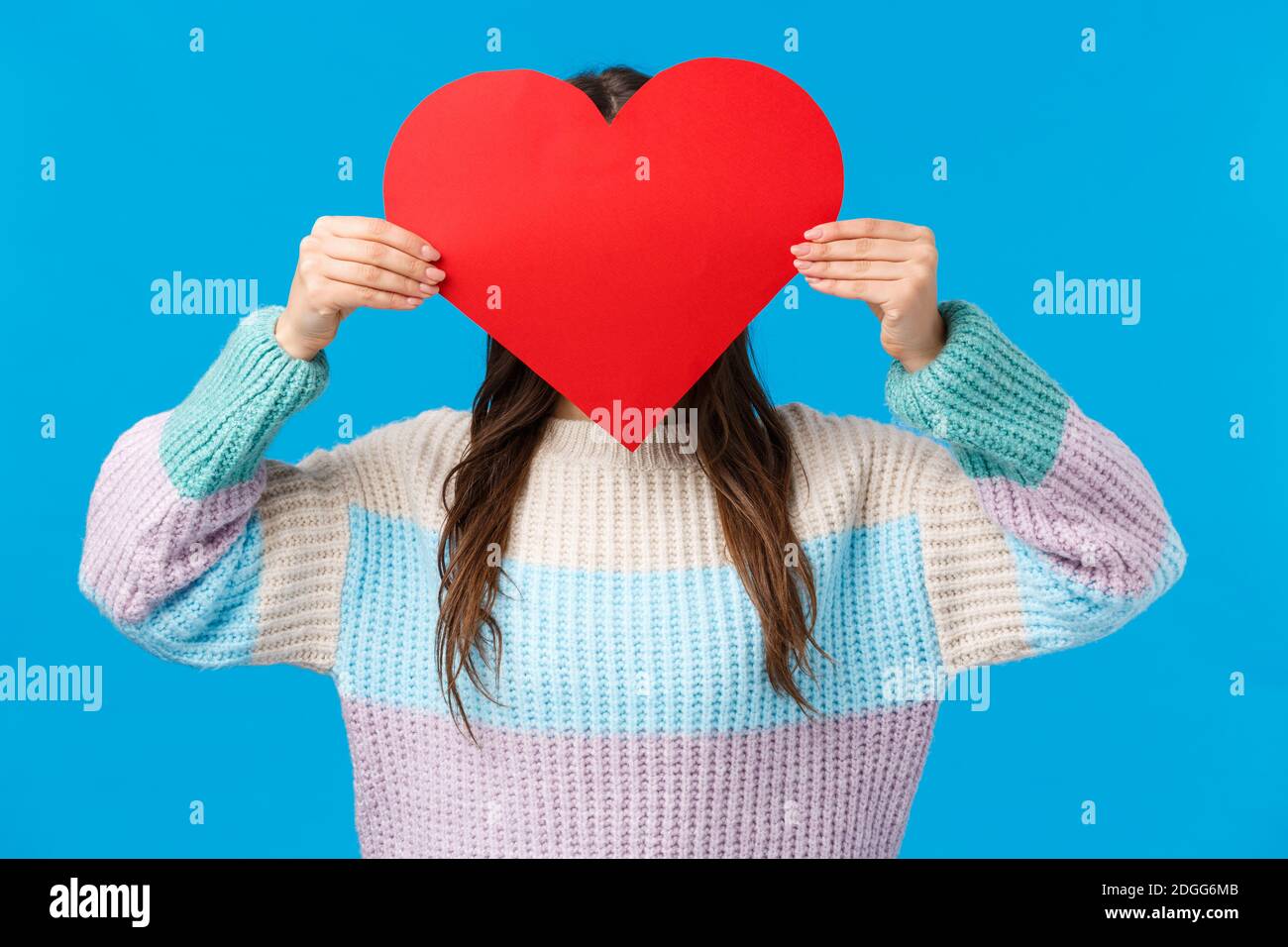 Be my valentine. Cute romantic shy girl in sweater hiding head behind ...