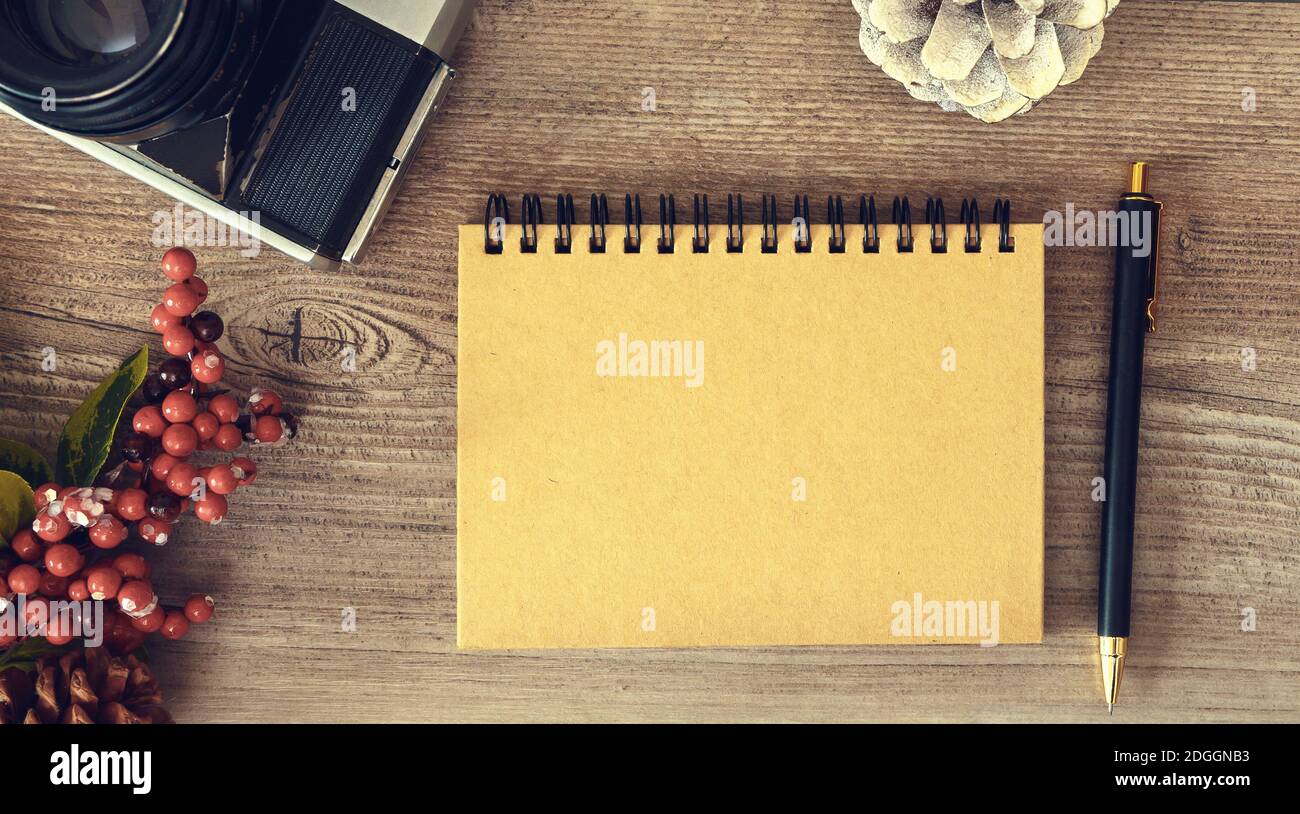 Notepad with pen and retro photo camera on wooden surface Stock Photo ...