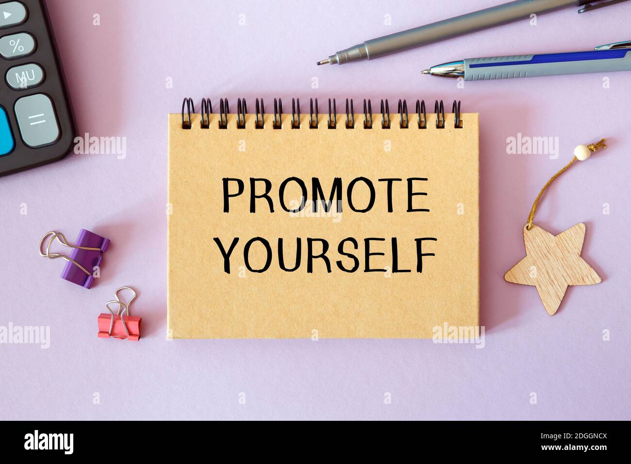 PROMOTE YOURSELF is written on a notepad on an office desk with office ...
