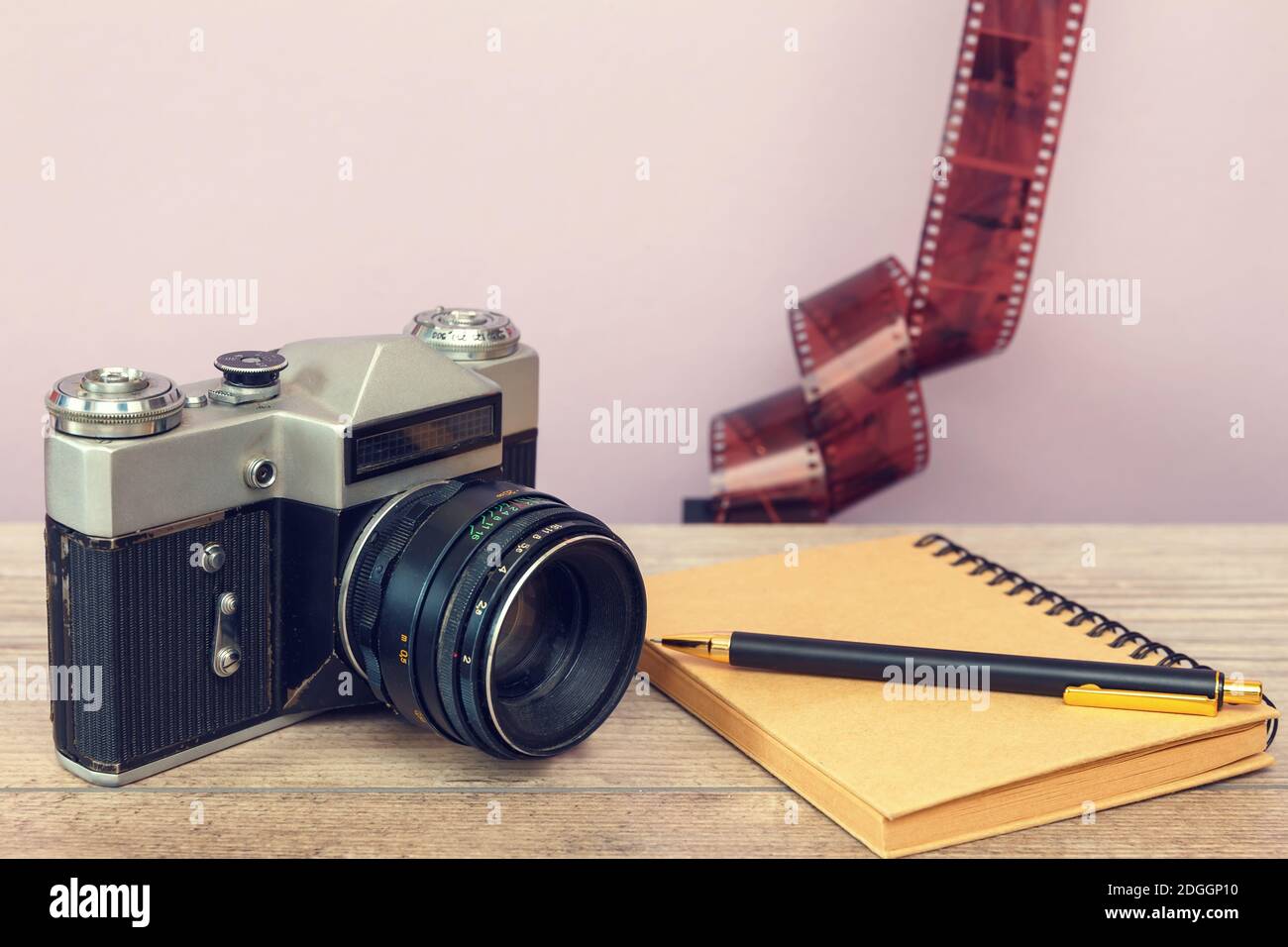 Notepad with pen and retro photo camera on wooden surface Stock Photo ...