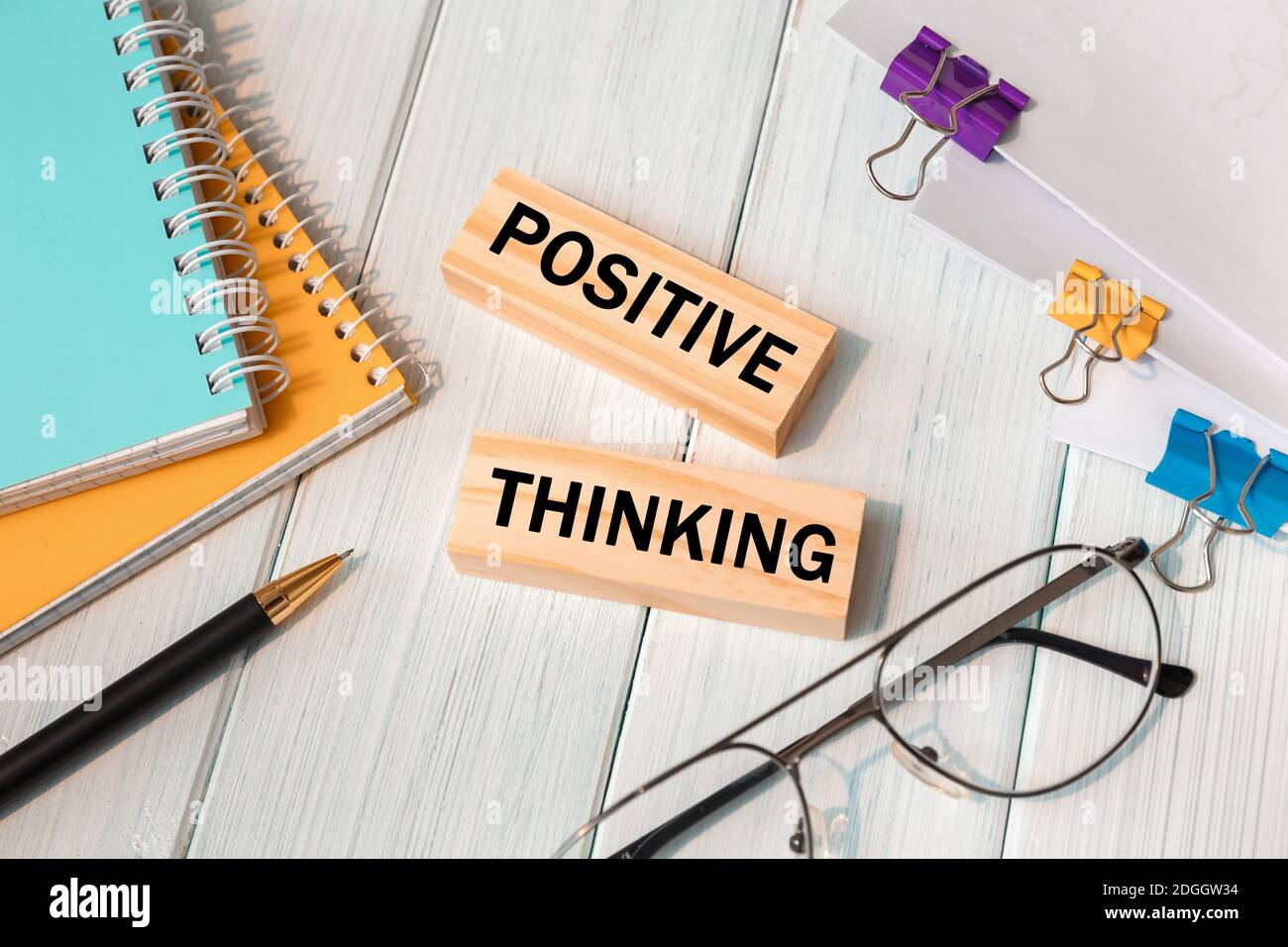Positive thinking - words written on wooden blocks near office supplies ...