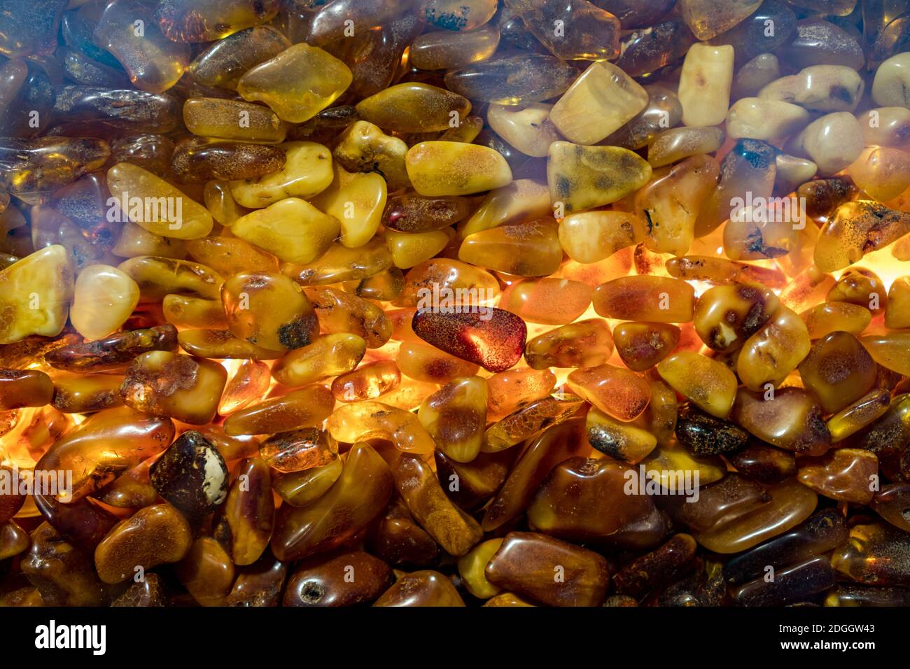 Amber grains with backlight illumination as texture or background. heap ...