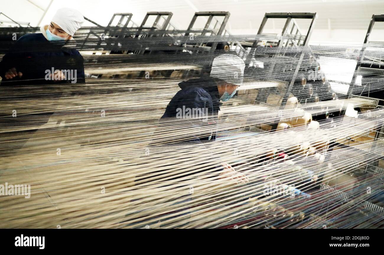 Local workers, standing along the production line, are busy at ...