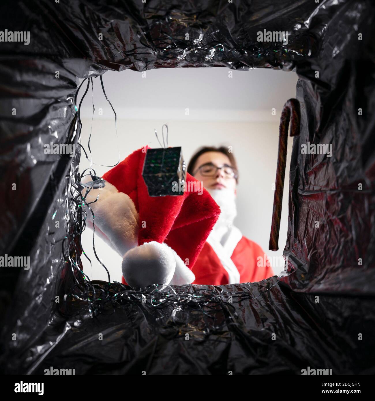 Santa takes off his hat and throws it into the trash with the presents ...