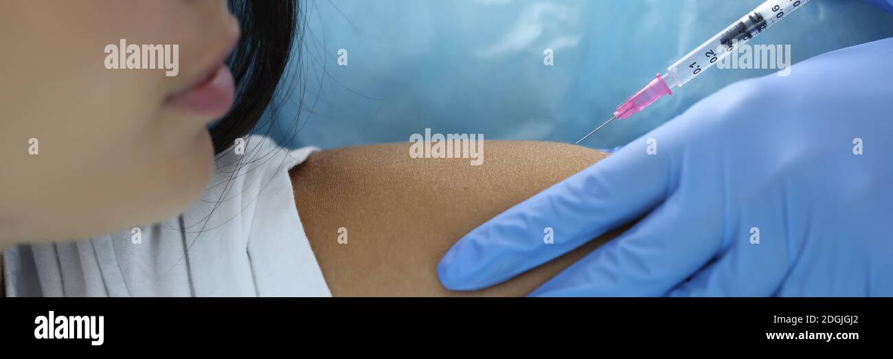 Doctor gives patient an injection in shoulder Stock Photo - Alamy