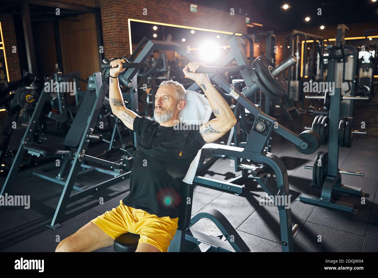 Professional athlete using the plate-loaded shoulder press machine ...