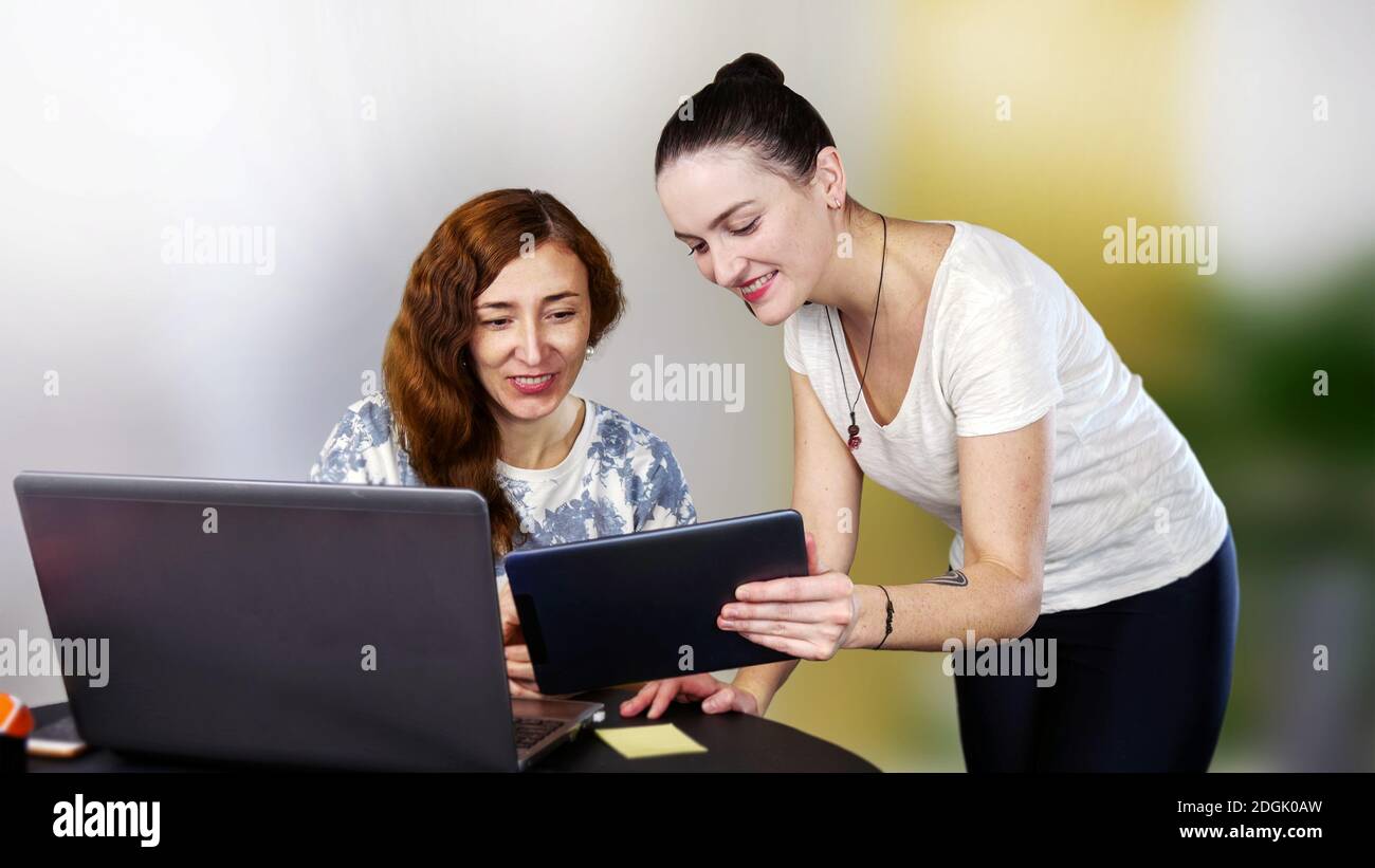 Two women at work laughing together hi-res stock photography and images - Alamy