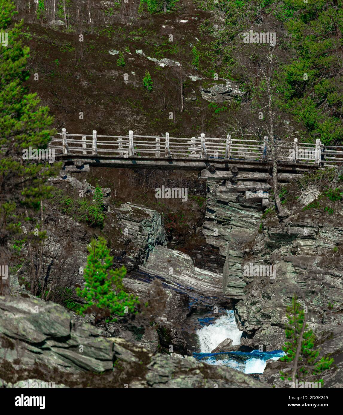Old wooden bridge in the mountains leading a road over a gorge with a ...