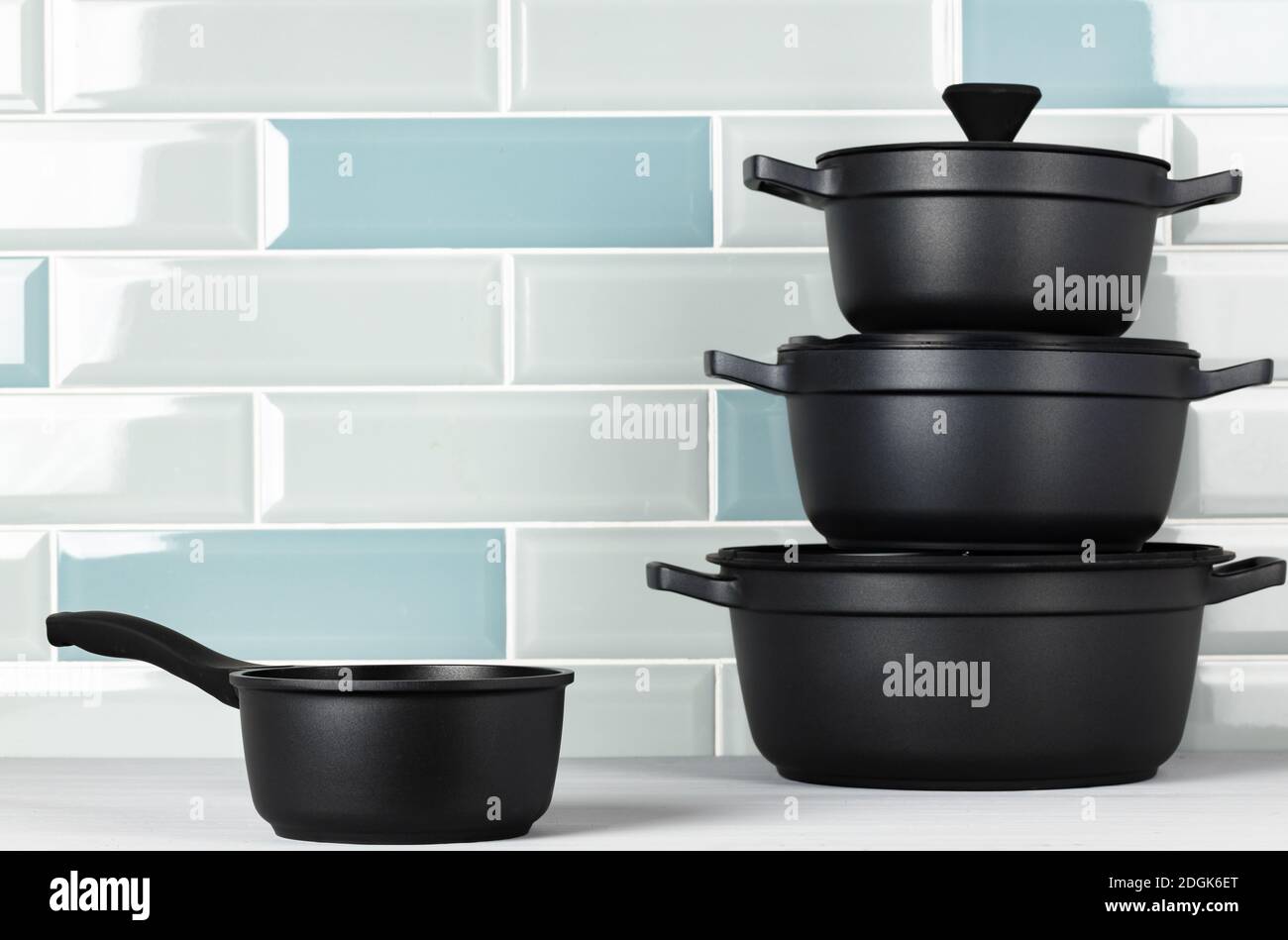 Set of black cookware on kitchen counter Stock Photo - Alamy